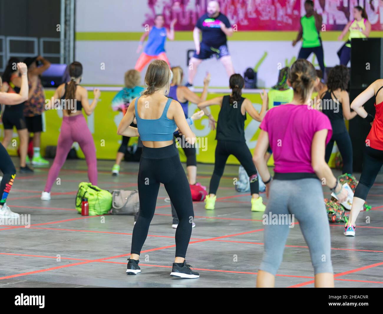 Fitness Workout in Gym: People doing Exercises in Class with Music and ...