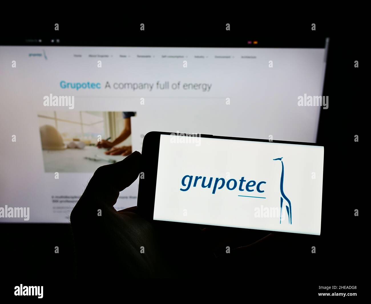 Person holding smartphone with logo of energy company Grupotec ...