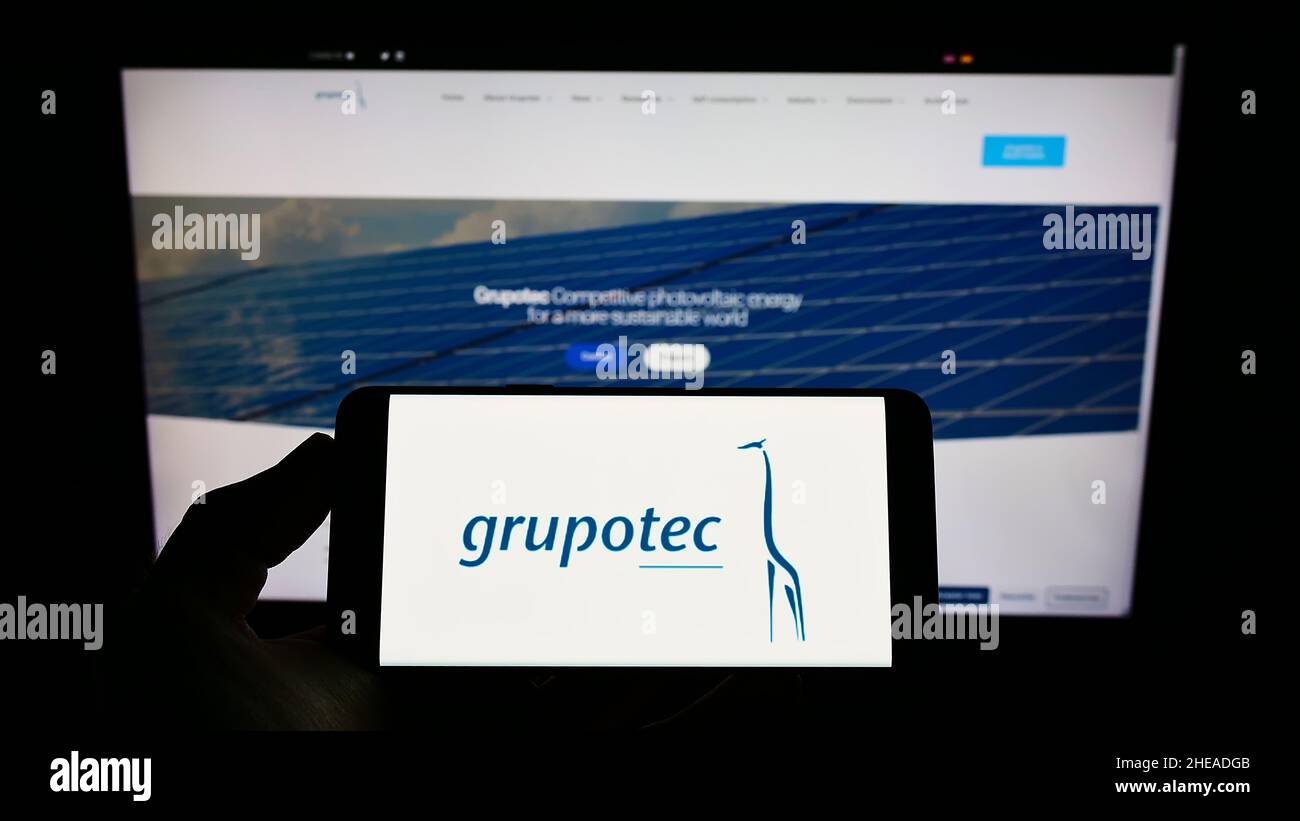 Person holding mobile phone with logo of energy company Grupotec ...