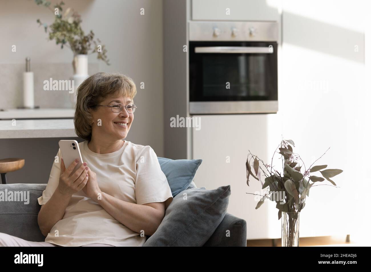 Dreamy happy old middle aged woman using cellphone Stock Photo - Alamy