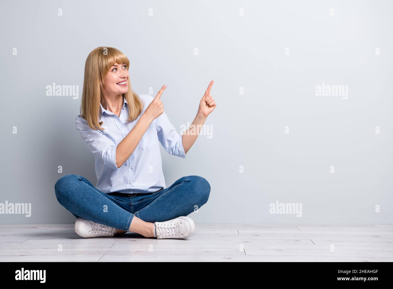 Full body photo of marketer lady sit floor legs crossed point hand ... Full body photo of marketer lady sit floor legs crossed point hand ...
