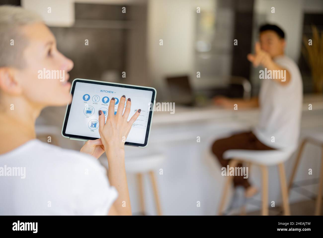 Woman push button on kitchen app on digital tablet Stock Photo - Alamy