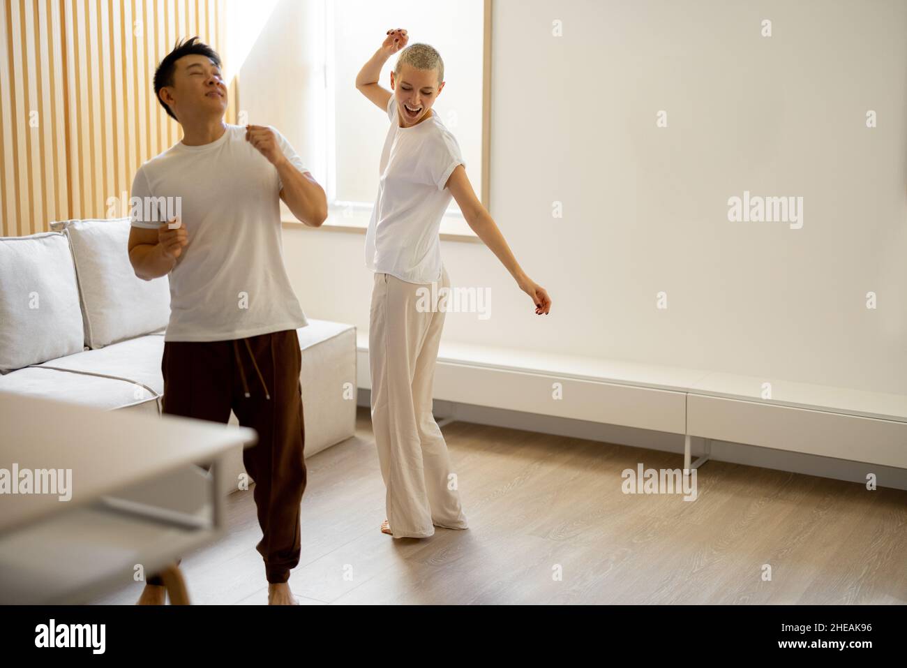 Multiracial couple dancing while resting at home Stock Photo - Alamy