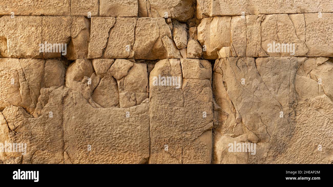 texture of an ancient wall made of huge stone blocks cracked from time ...