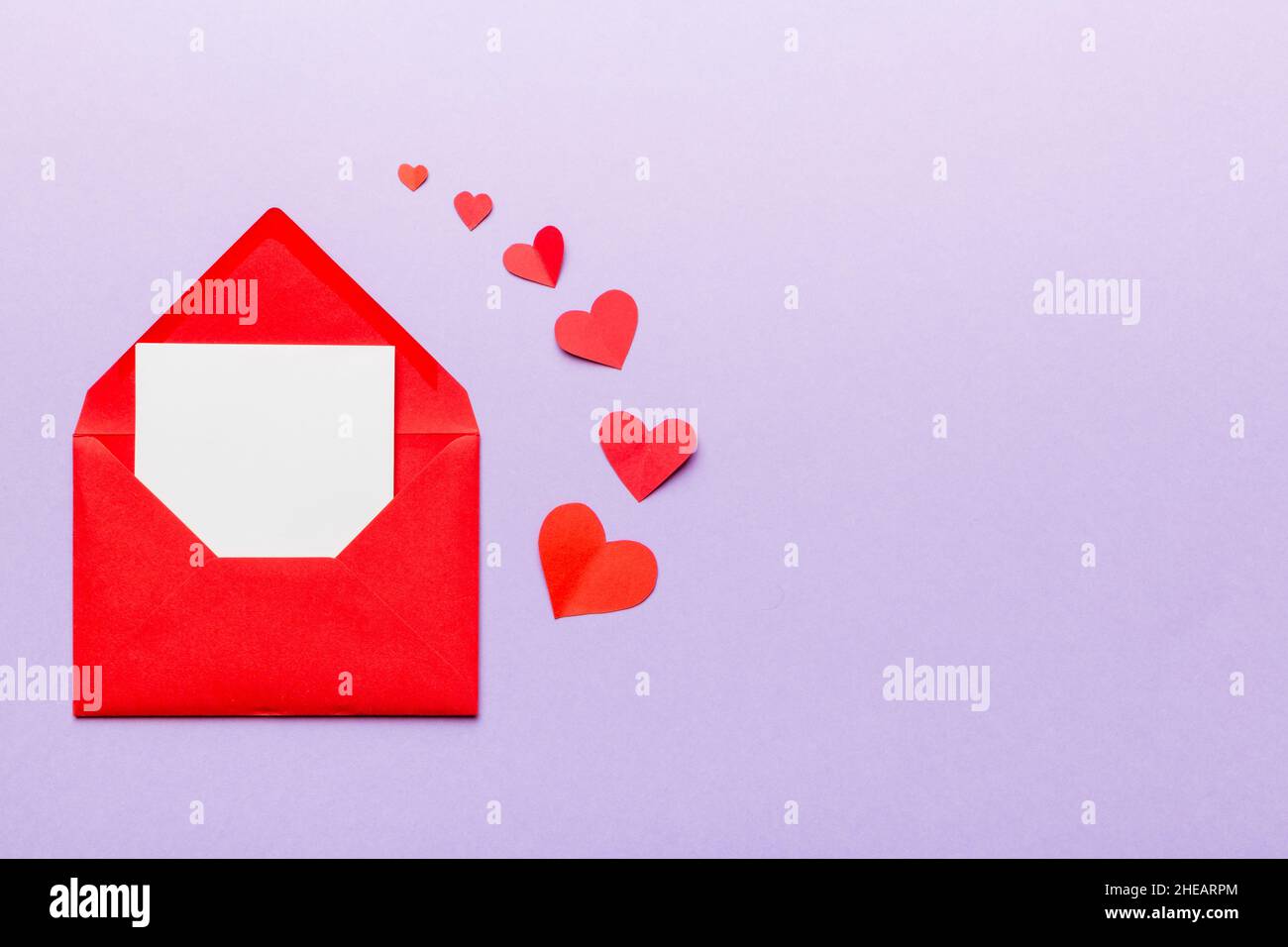 Red paper envelope with empty white card and heart on colored ...