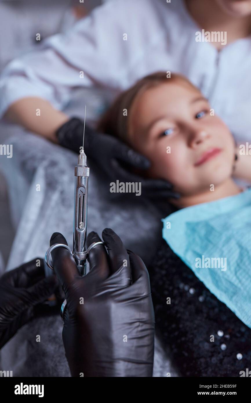 Little girl at dentist office, getting local anesthesia injection into ...