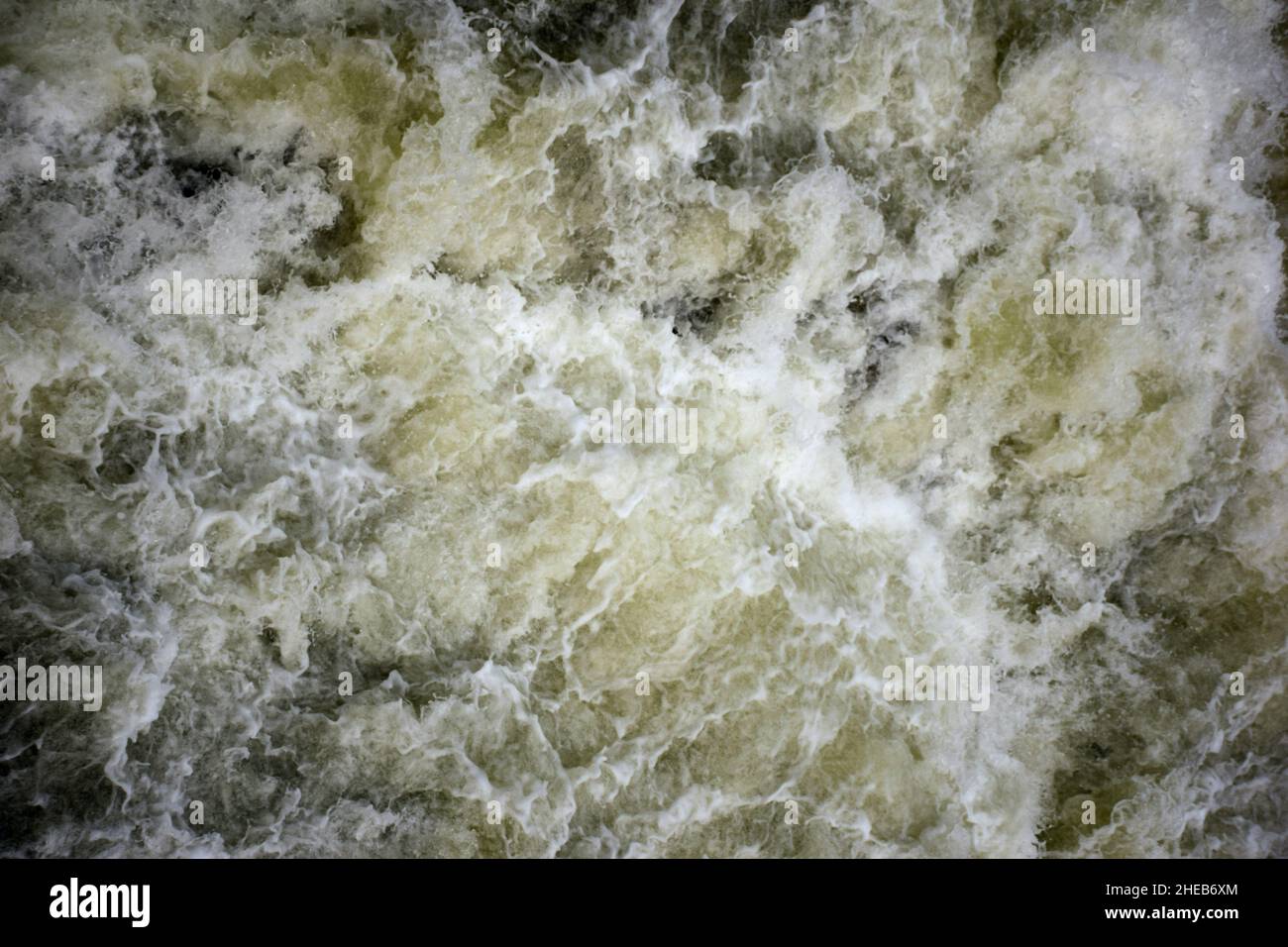 Bubbling stream of mountain river water with foam and splashes all over ...