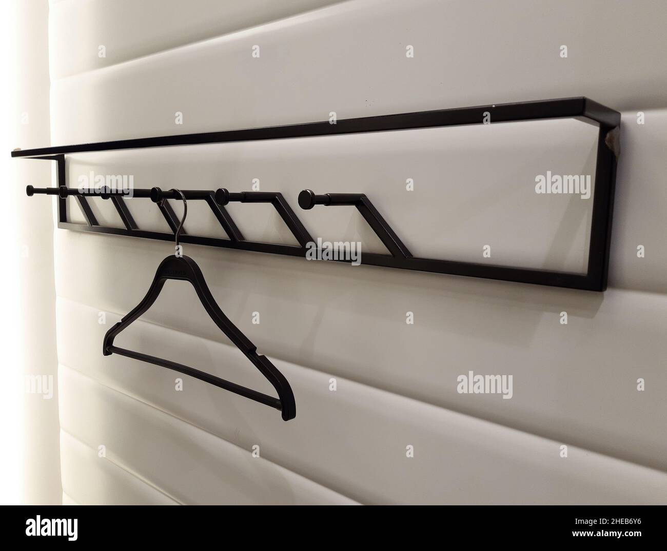 An empty hanger hangs on hooks in the store's fitting room ...