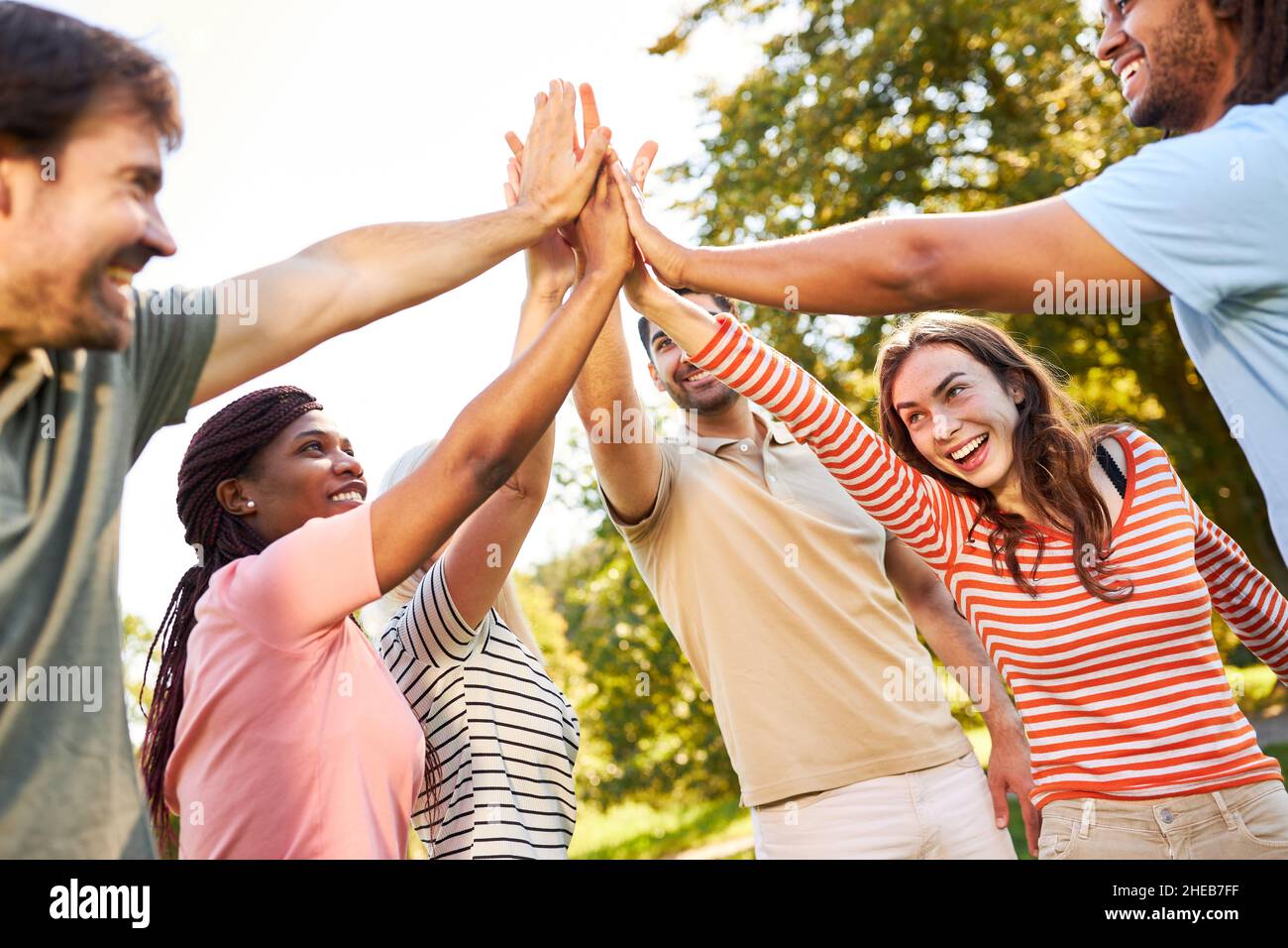 Group of young people giving high five for friendship and cooperation ...