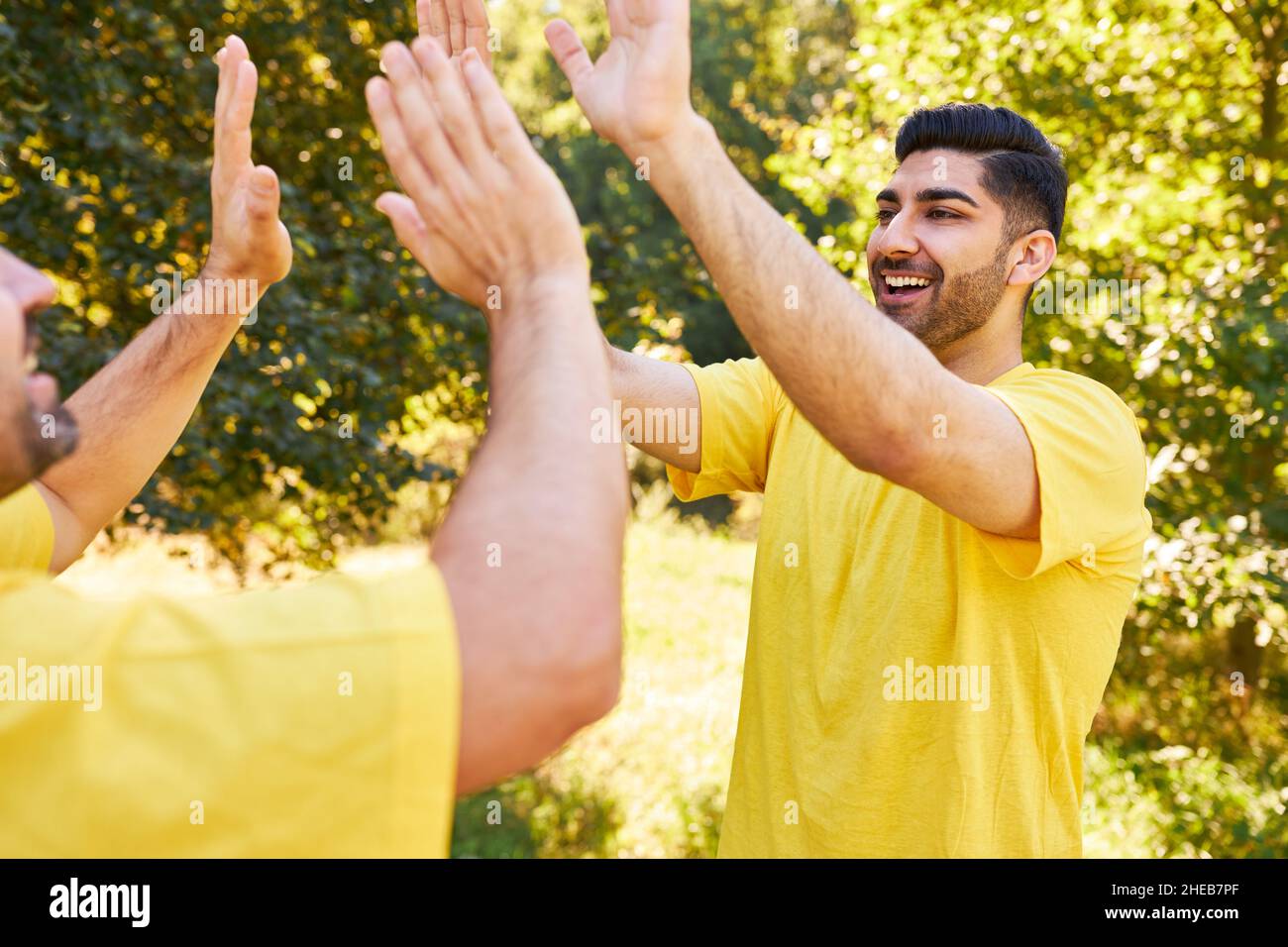 Two young people give a high five as a symbol of motivation and team ...