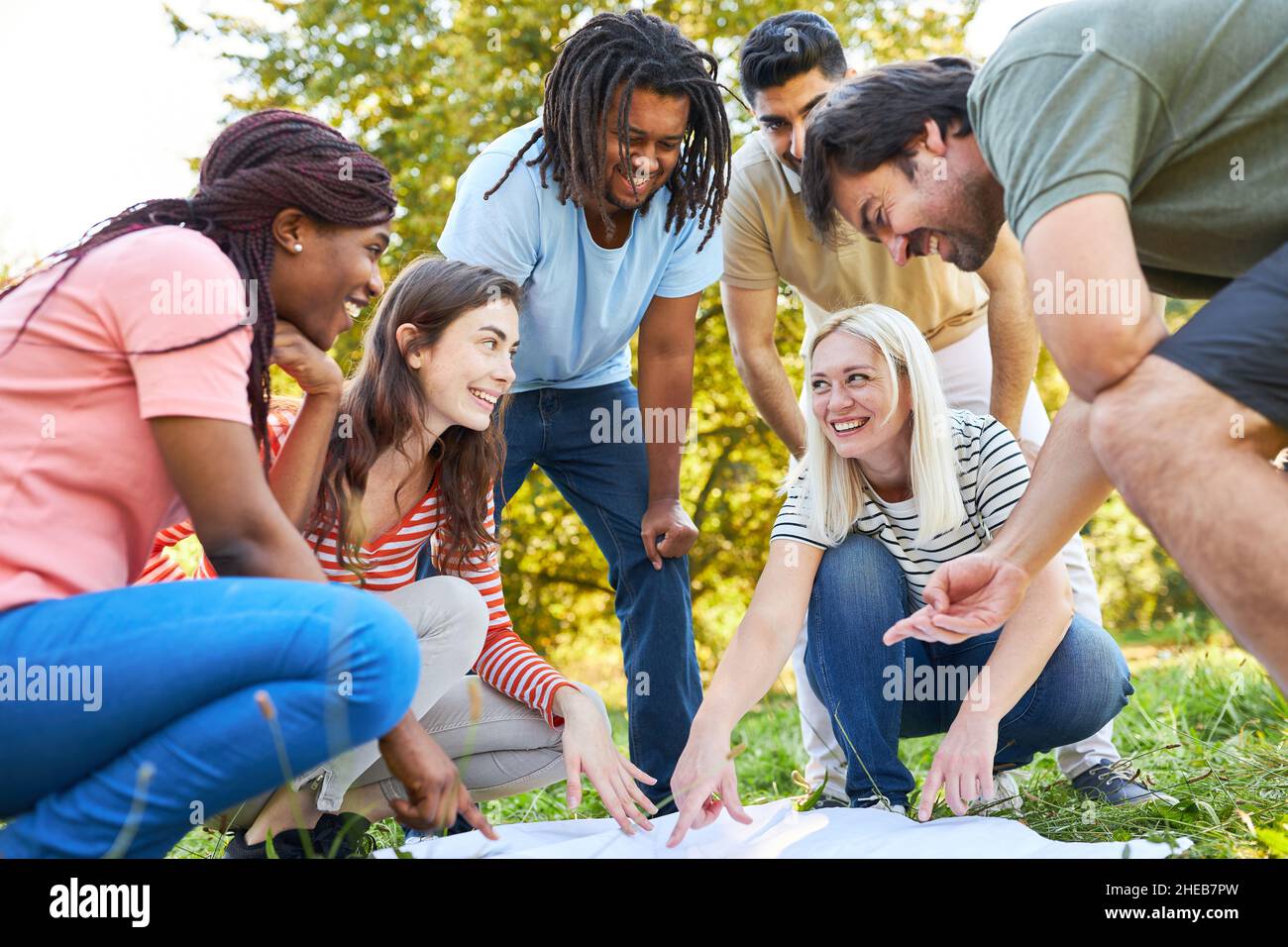 Happy group of friends playing terrain game with map in nature in ...