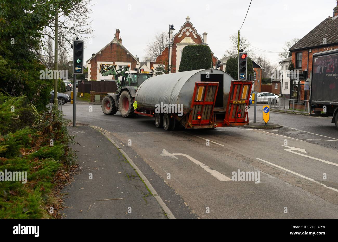 A tractor with a awkward load of a pig (sow) hut navigates the traffic ...