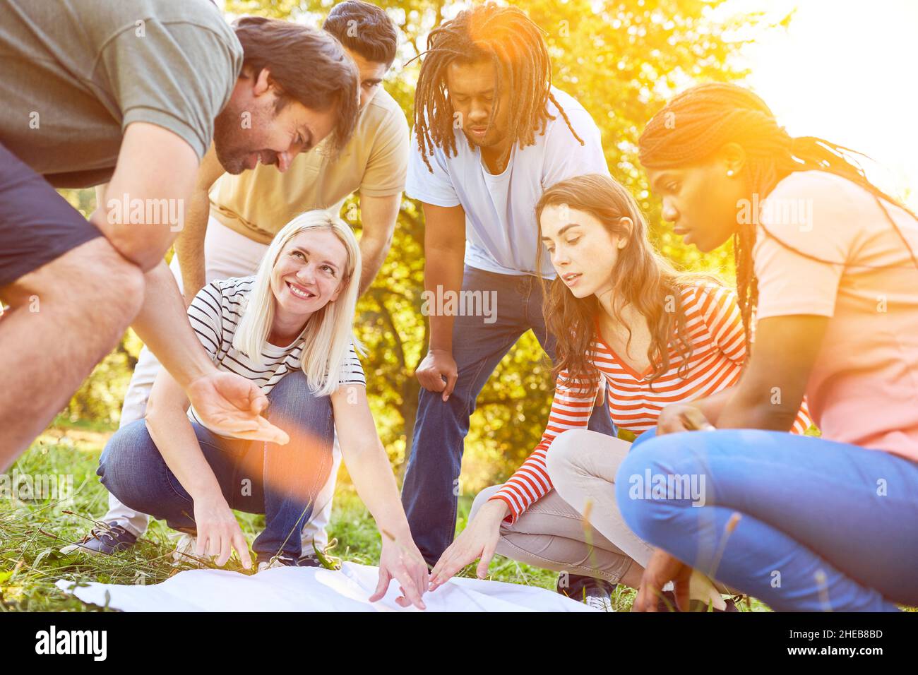 Happy team with map at geocaching treasure hunt as team building ...
