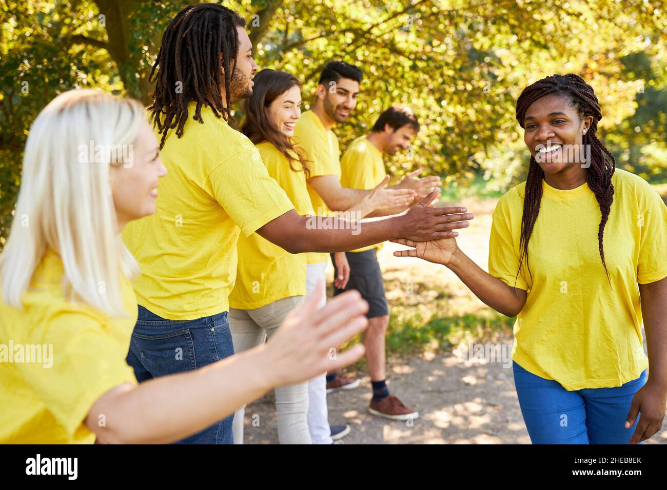 Young woman and team in the team building summer camp with a clap for ...