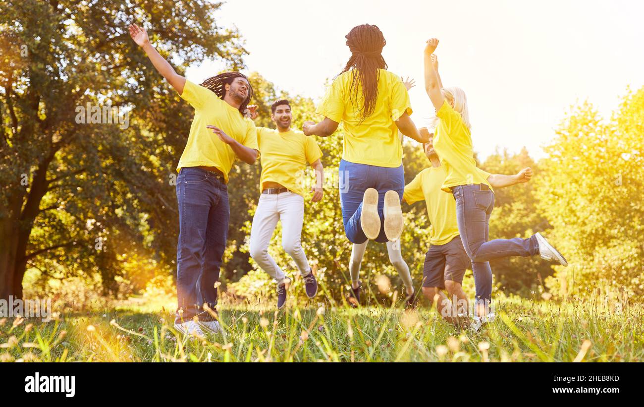 People as a team jump together at team building exercise in nature ...