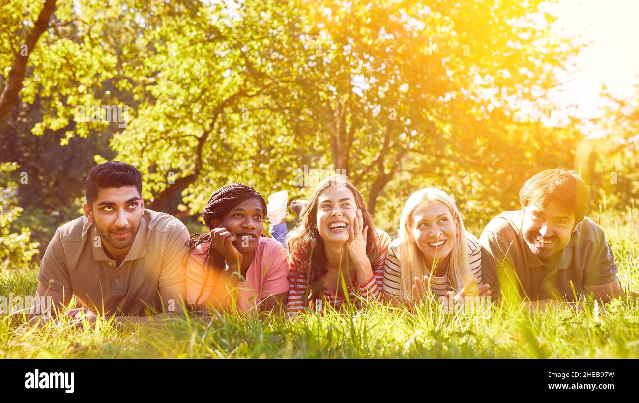 Happy friends lying together laughing in the park in summer Stock Photo ...