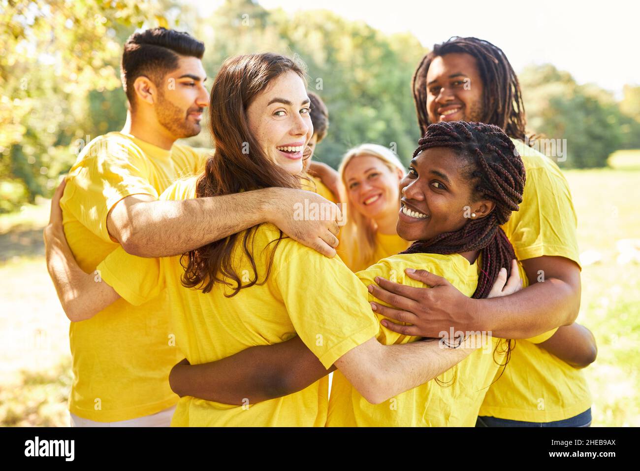 Multicultural start-up team hugs each other in the workshop for ...