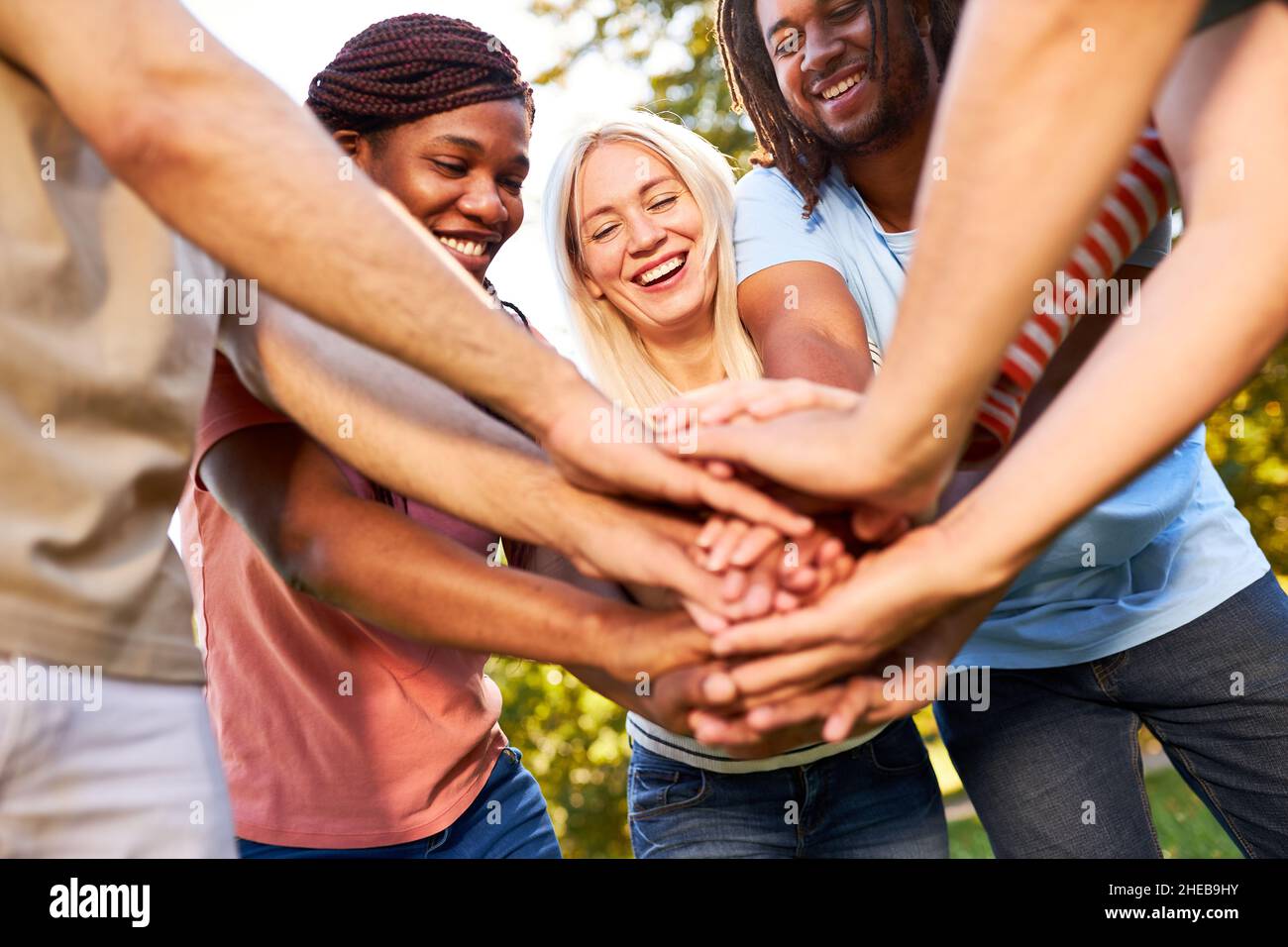 Group of friends stacking hands as a symbol of team building and ...