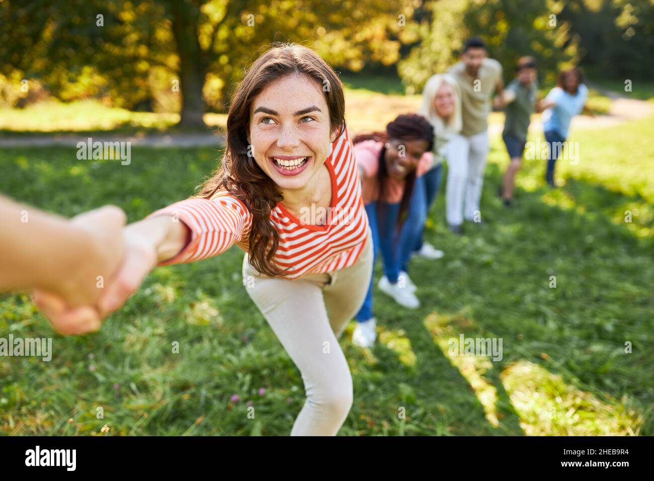 Young people pulling hands during a competition in team building ...