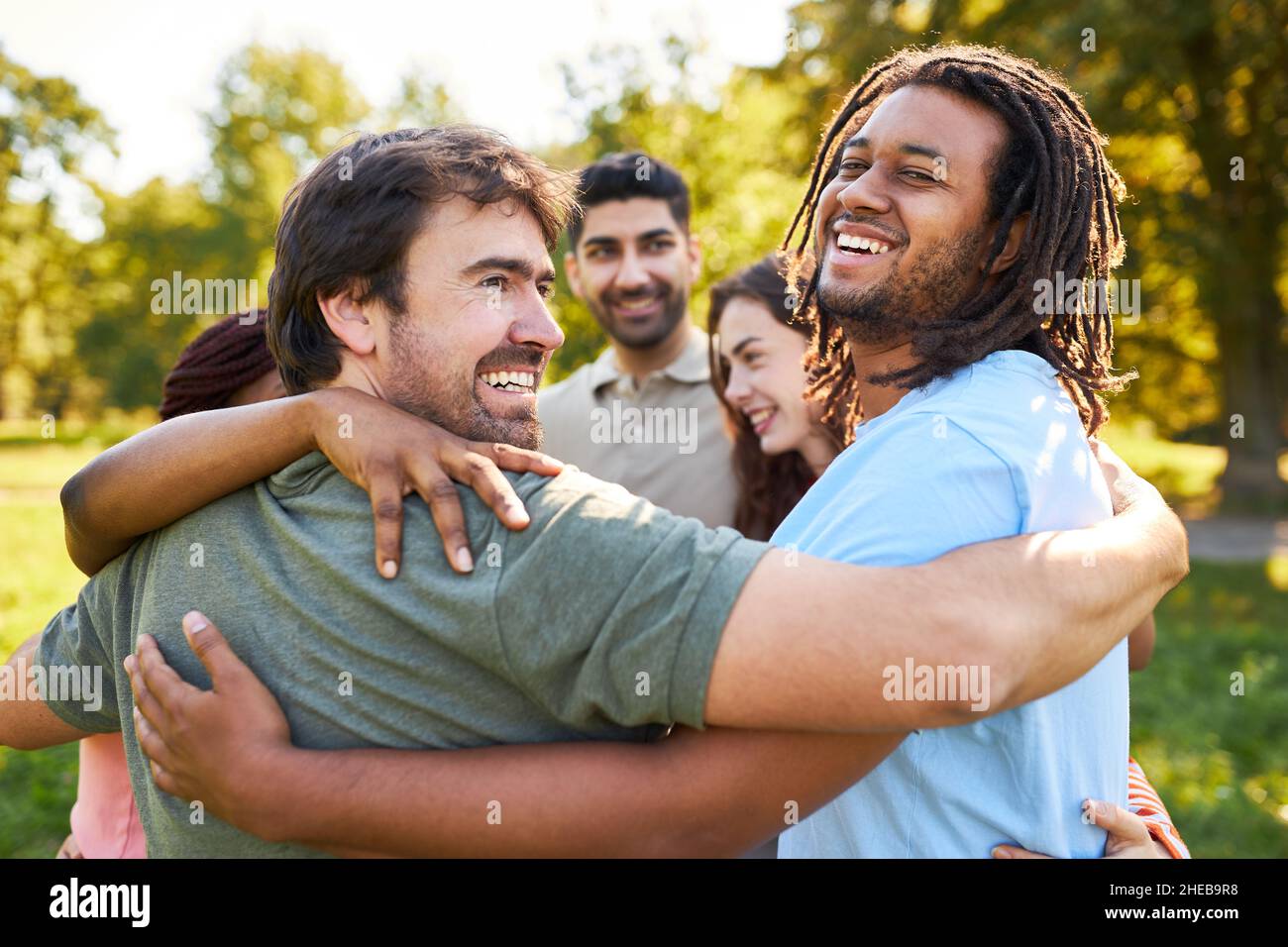 Successful young startup team hugs each other for motivation and team ...