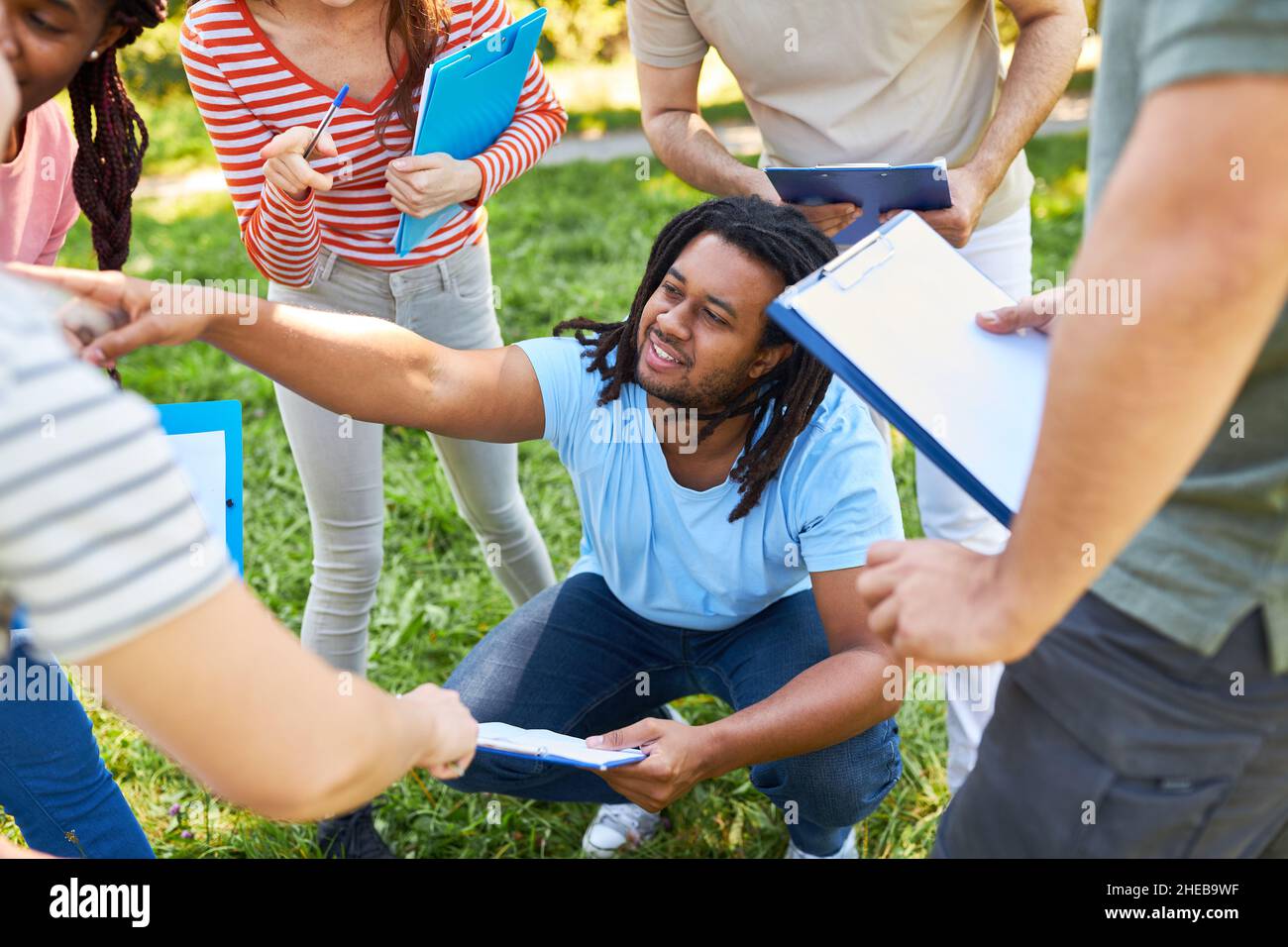 Young man shows the direction in the field game at the team building ...