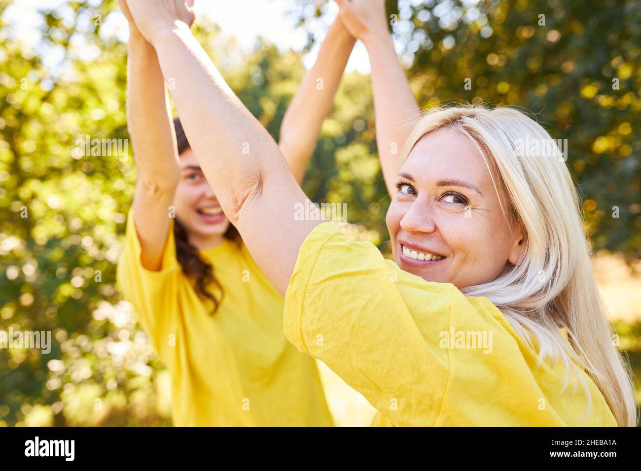 Two women celebrate a success together as friends at a team event in ...