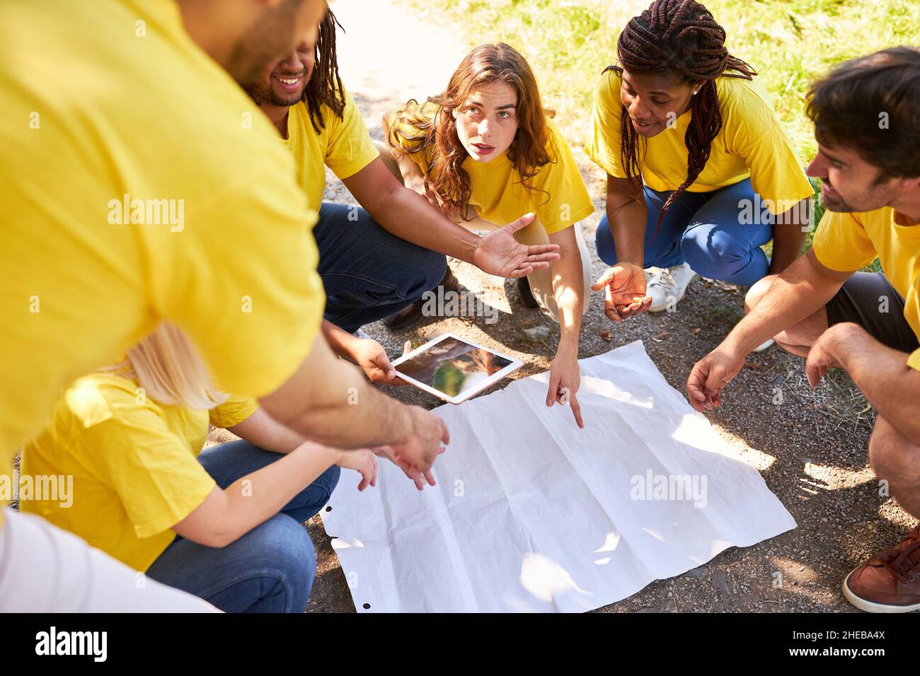 Start-up team with a map in the field game geocaching for advice and ...
