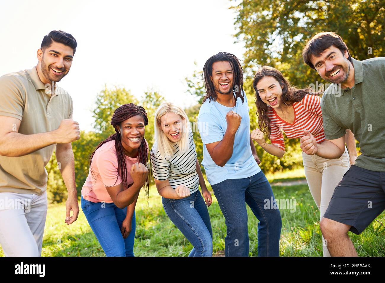 Young people in the startup team cheering with clenched fists at the ...