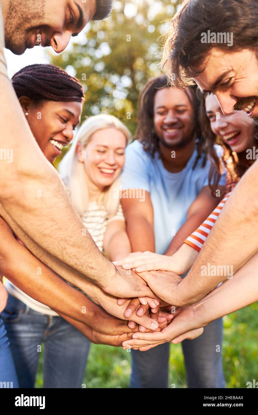 Friends stacking hands as a symbol of friendship and team building in ...