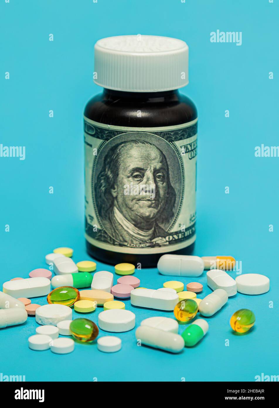 Money and pills of different colors on a blue background. The rise in ...