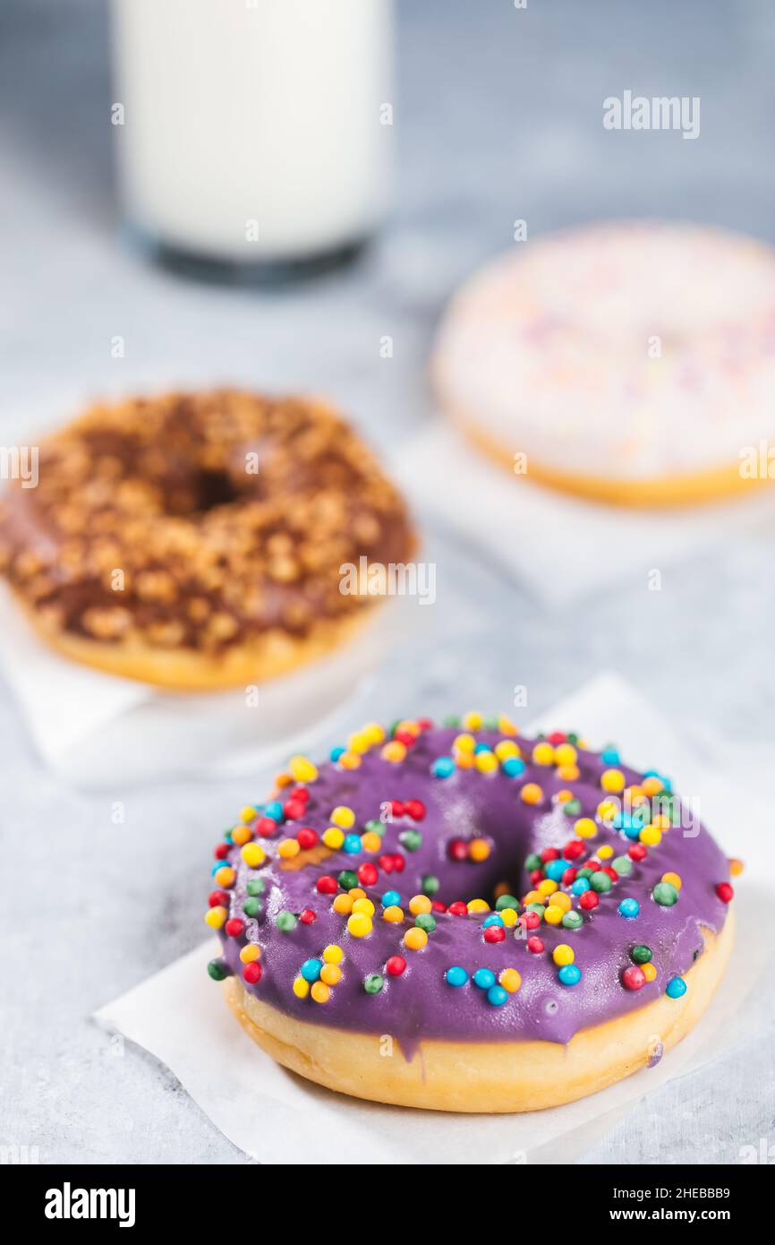 Selection of donuts with different colors on a grey background with ...