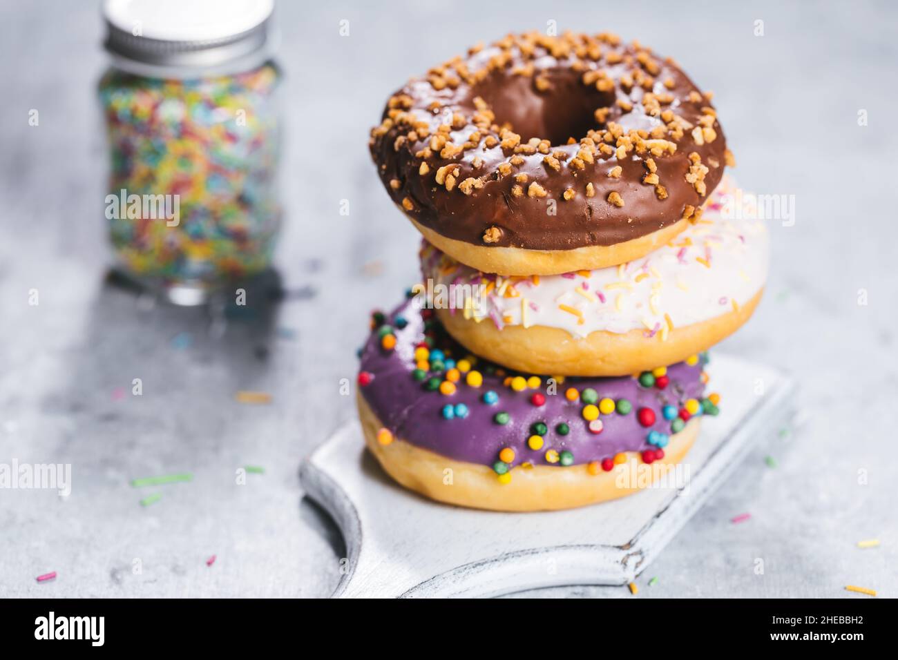Selection of donuts with different colors on a grey background with ...