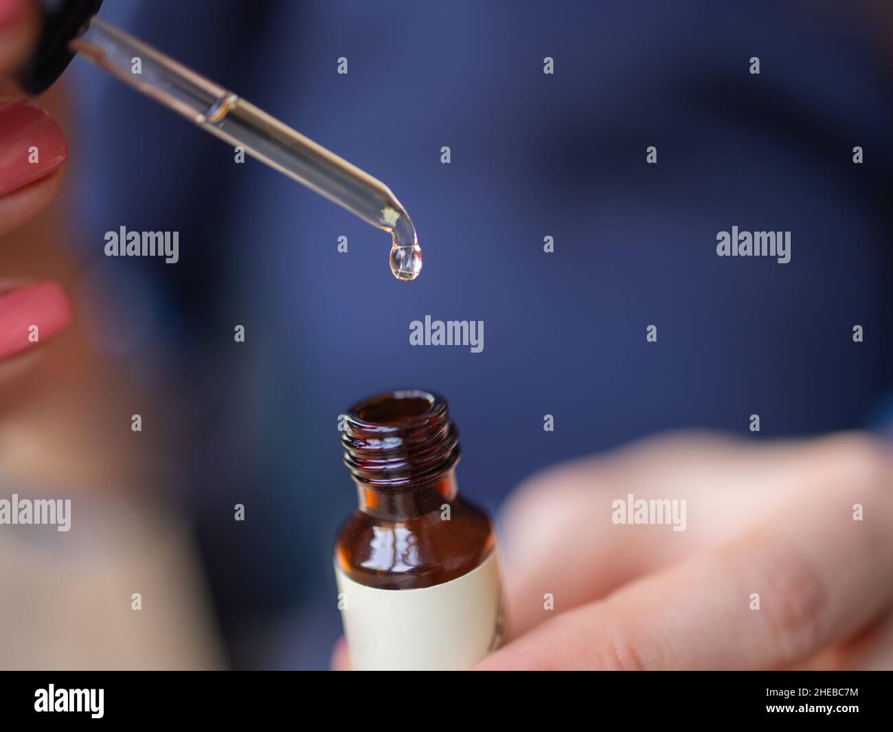 Drop falls from a pipette into a cosmetic bottle Stock Photo - Alamy
