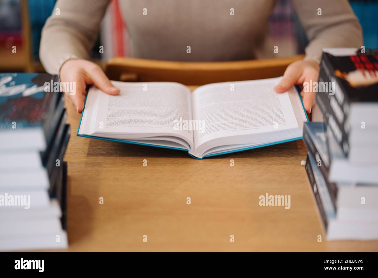 Teen girl among a pile of books. A young girl hands holding an opened ...