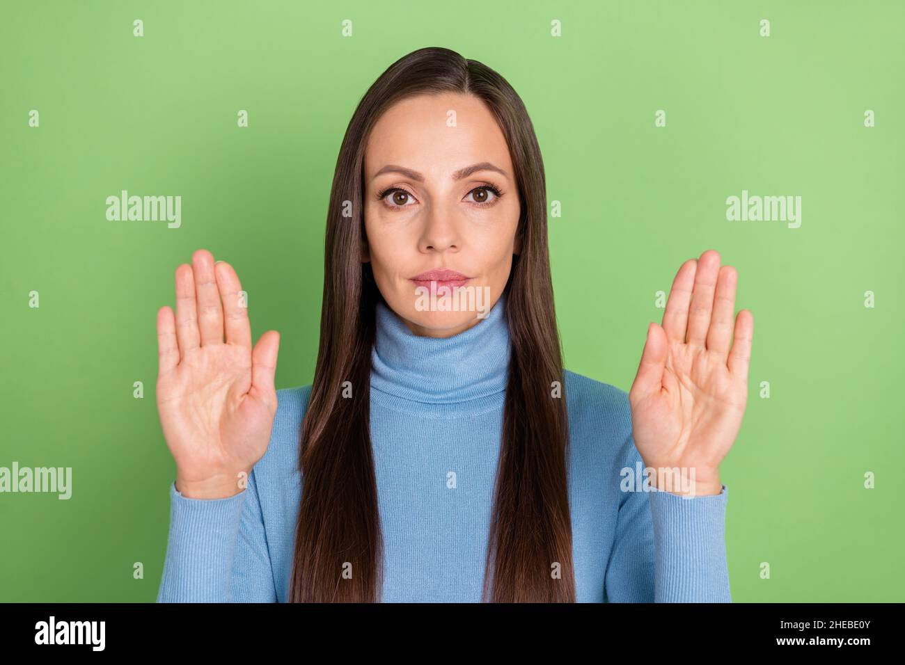 Portrait of attractive strict serious long-haired girl showing palms ...