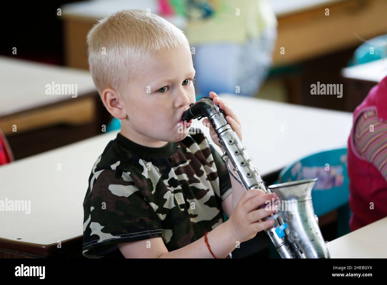 Preschooler boy playing on a toy saxophone Stock Photo - Alamy