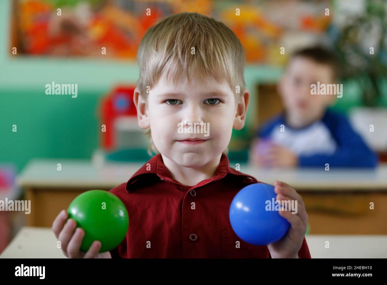 A preschooler boy holds colored balls in his hand Stock Photo - Alamy