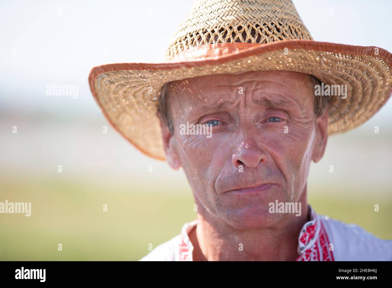 An elderly Belarusian or Ukrainian man wearing a straw hat. Village ...