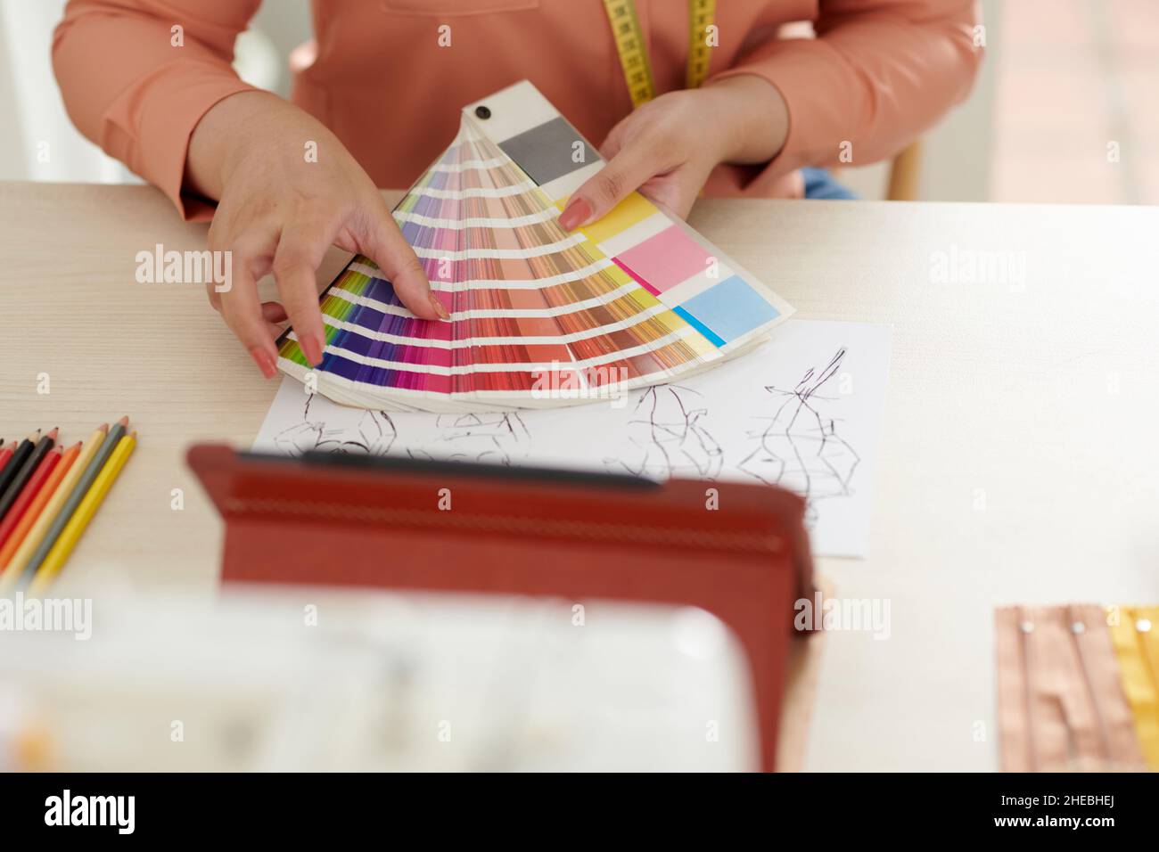 Hands of fashion designer working with palette of swatches when working ...