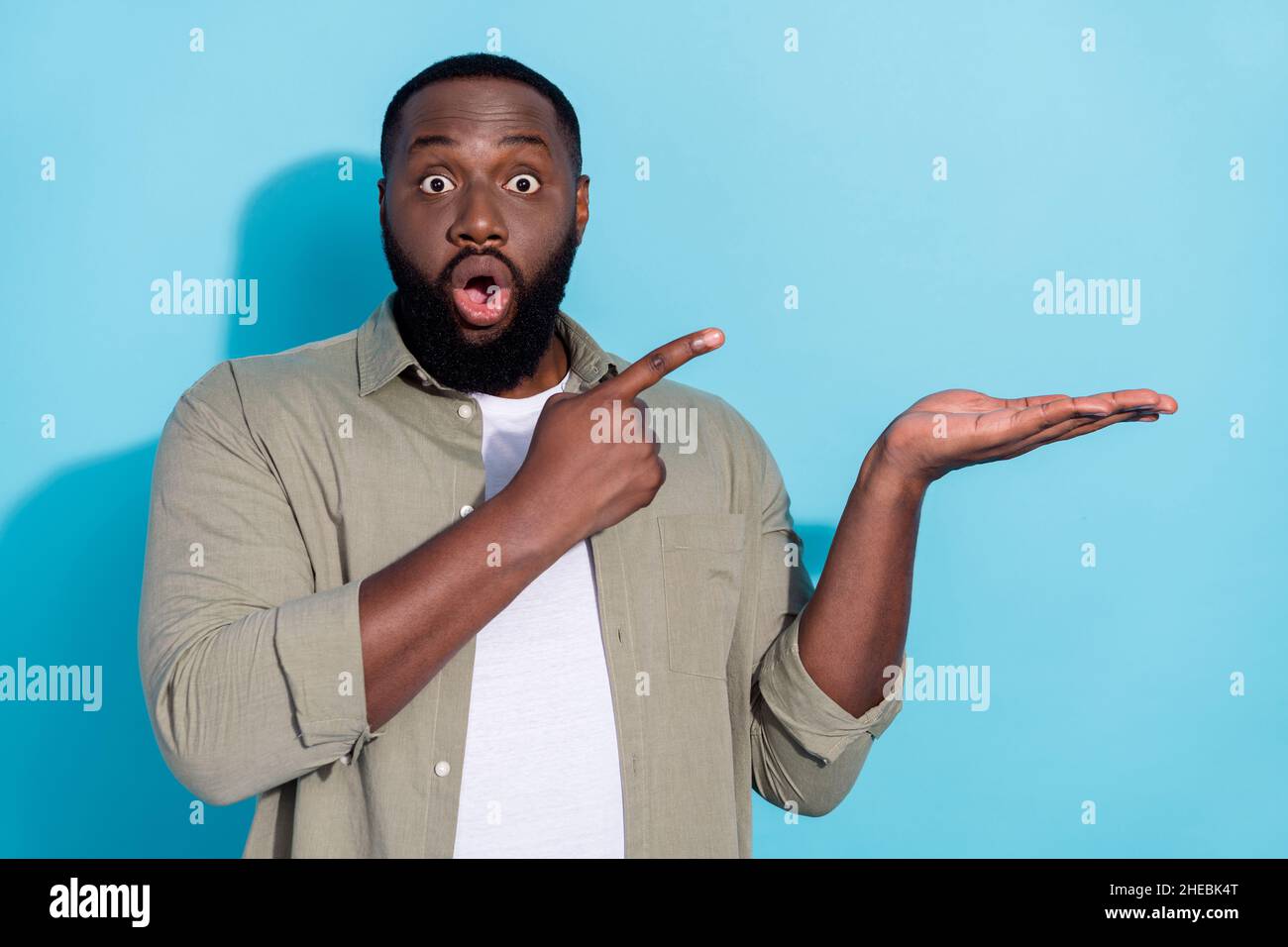 Photo of young astonished african man indicate finger advert banner ...