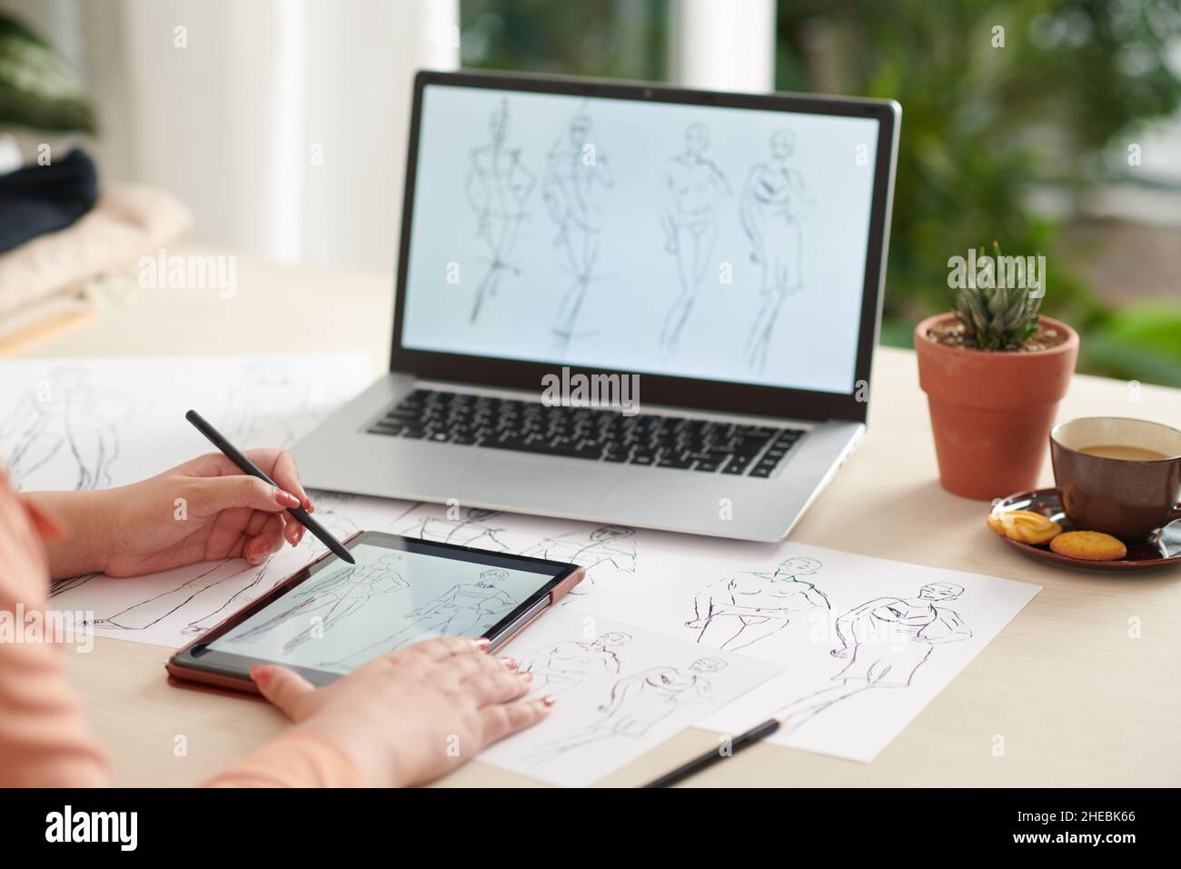 Fashion designer drawing illustrations for new collection at her home ...