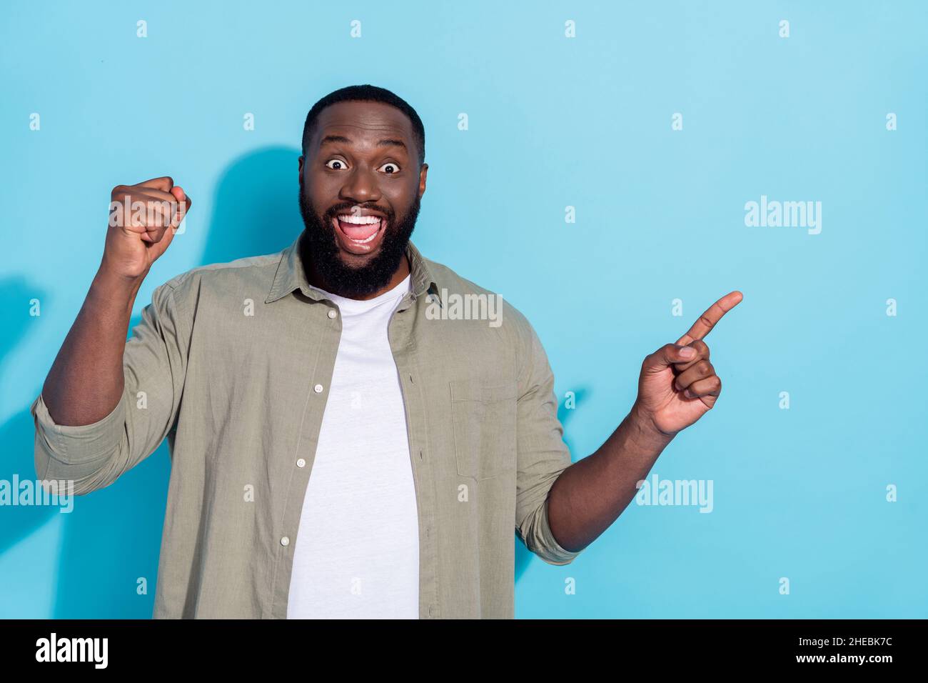 Photo of young african man rejoice success fists hand indicate finger ...
