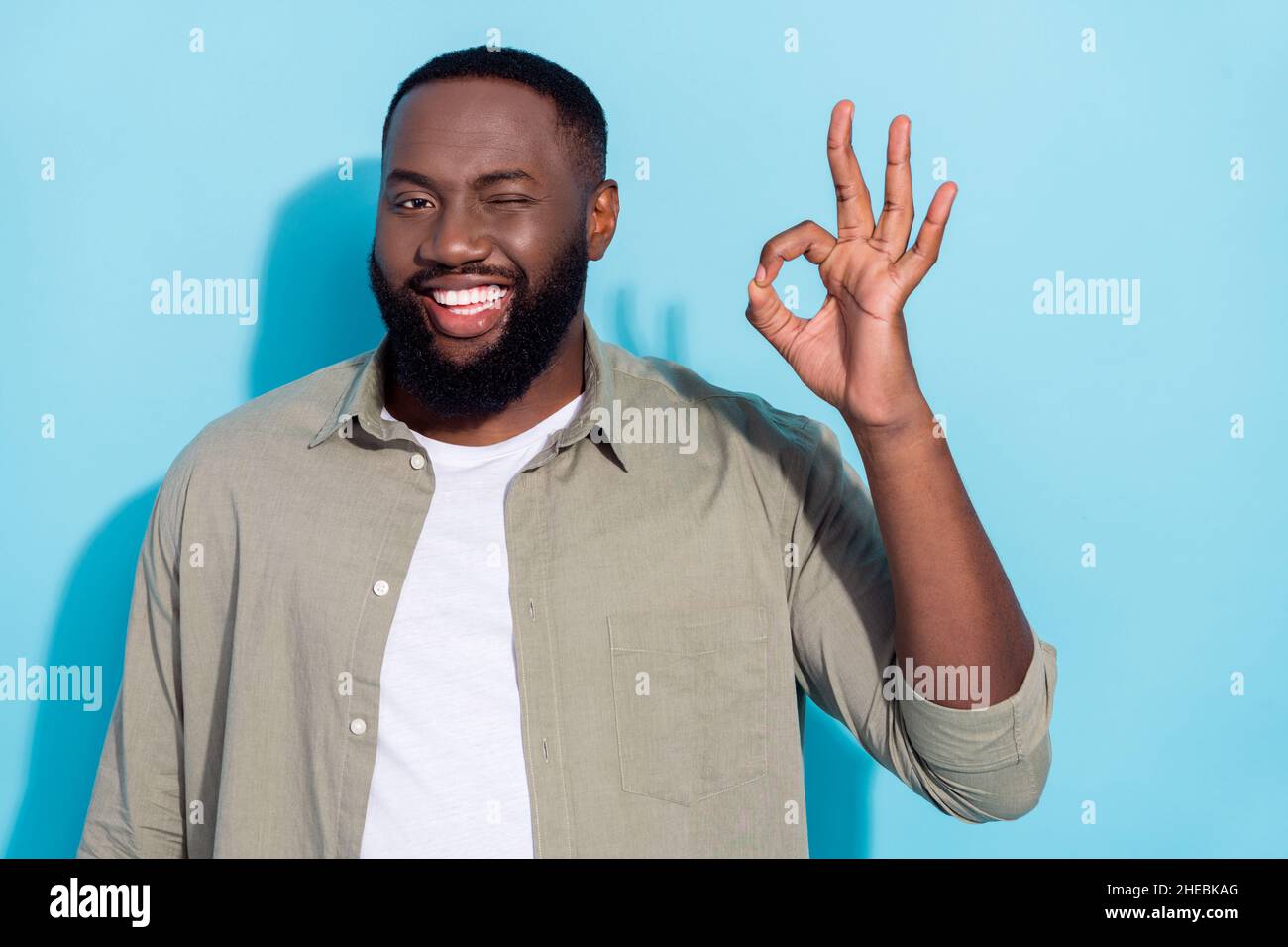 Photo of young cheerful african guy wink eye promoter approve good ads ...