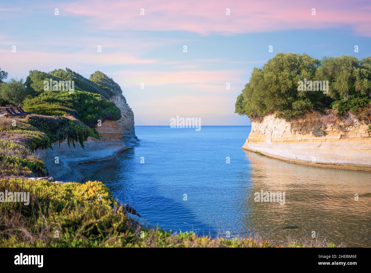 Shore with clear blue sea water straight between islands with dense ...