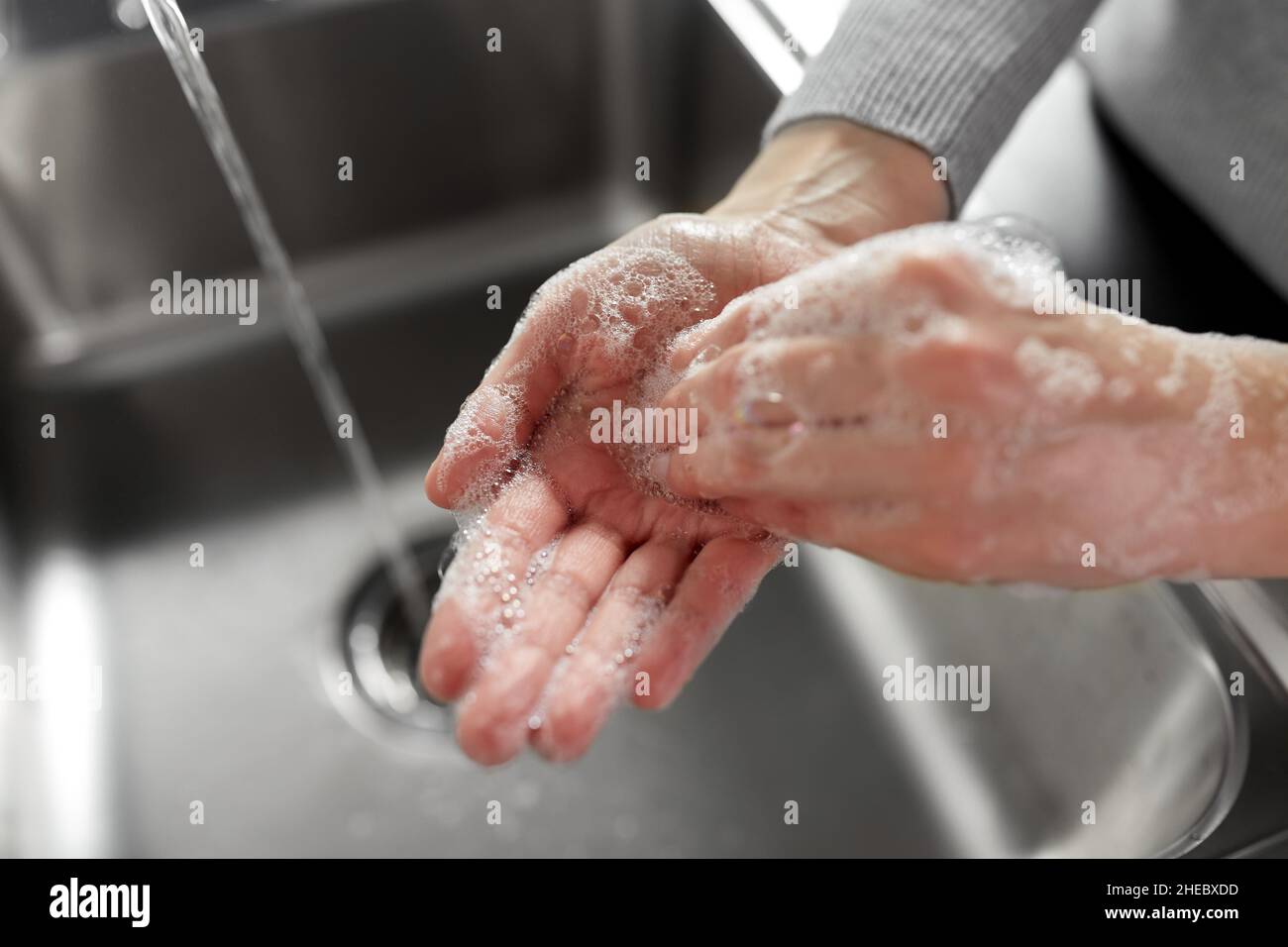 woman washing hands with soap in kitchen Stock Photo - Alamy