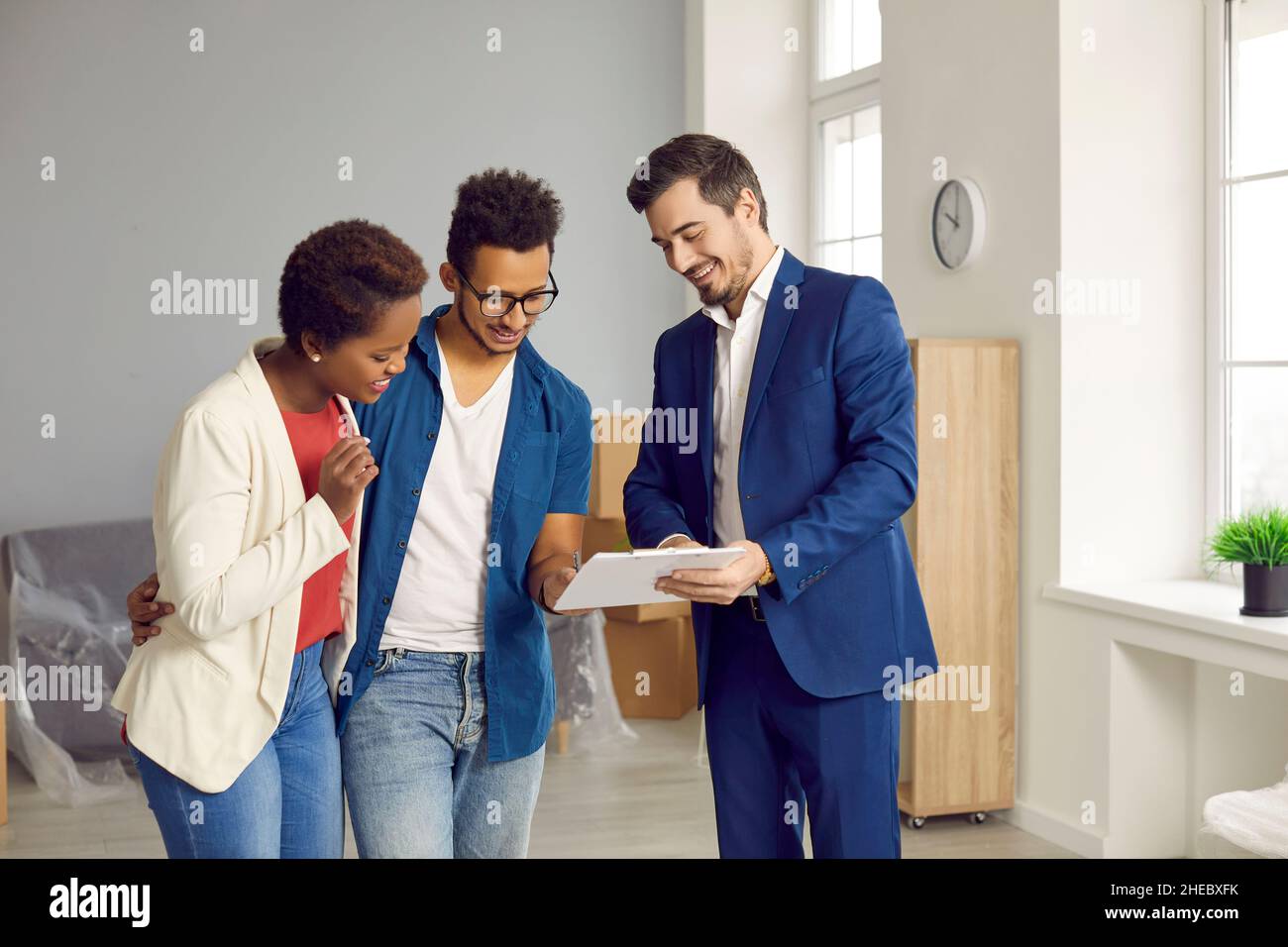 Male realtor show house plan to couple buyers Stock Photo - Alamy