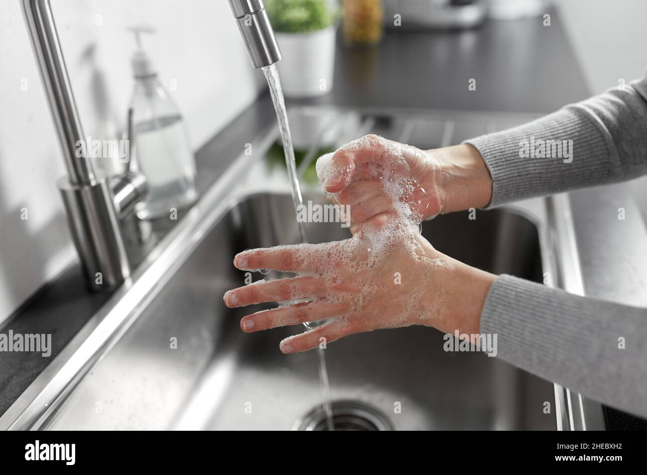 woman washing hands with liquid soap in kitchen Stock Photo - Alamy