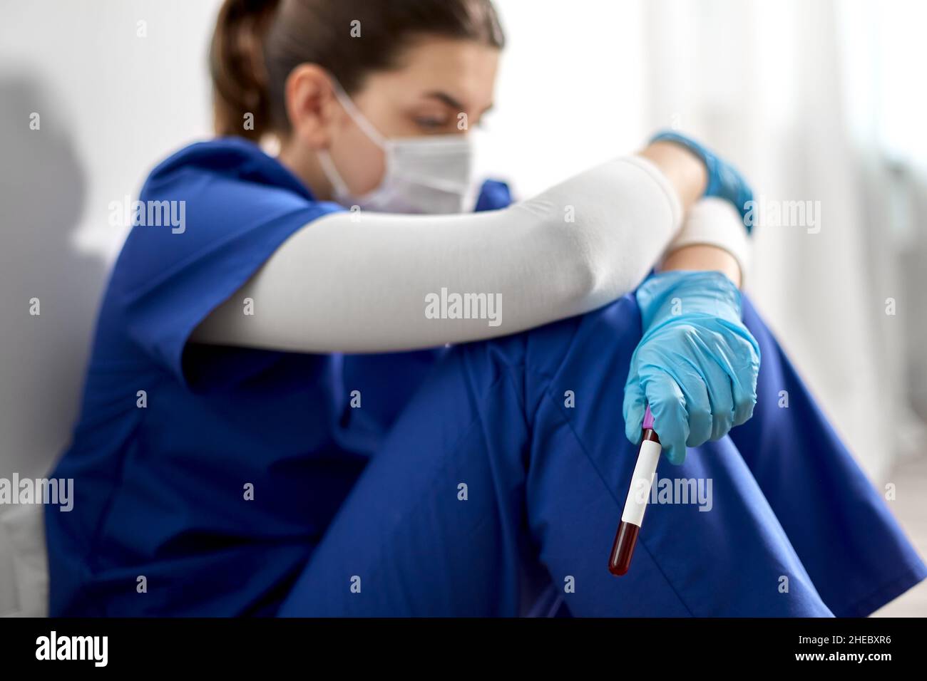 sad doctor or nurse holding beaker with blood test Stock Photo - Alamy
