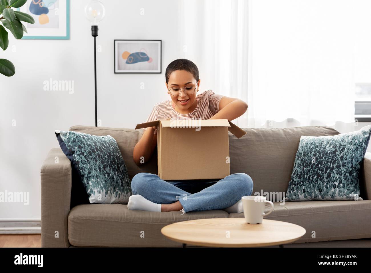 african american woman opening parcel box at home Stock Photo - Alamy