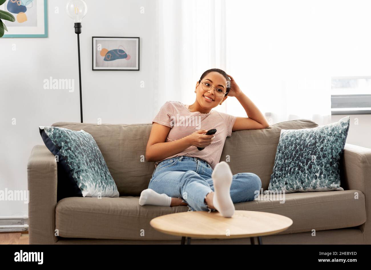 happy african american woman watching tv at home Stock Photo - Alamy